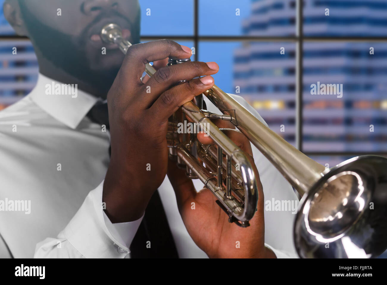 Concentrated trumpet player. Trumpet player on city background ...