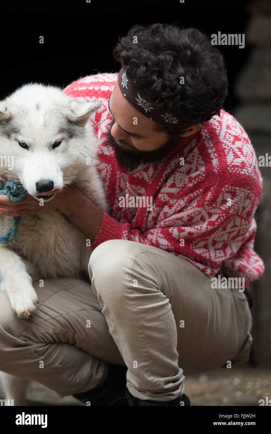 handsome young hipster man standing together with white husky dog in ...