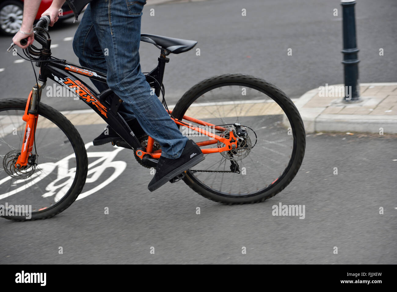 Cyclist waiting at road junction Stock Photo - Alamy