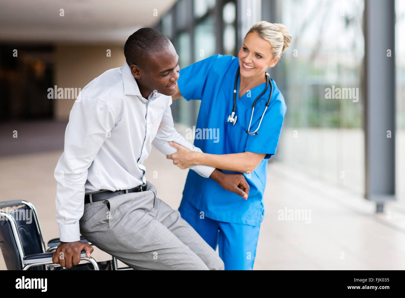 friendly medical nurse helping handicapped man getting up from ...