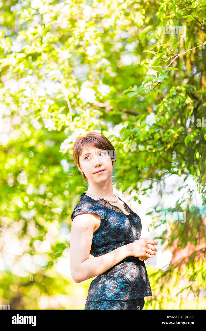Spring woman in summer dress walking in green park enjoying the sun ...
