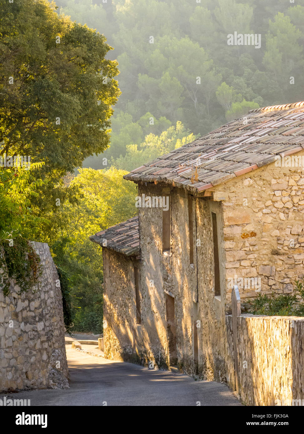 Old stone house with tile roof on a narrow street in the historic ...