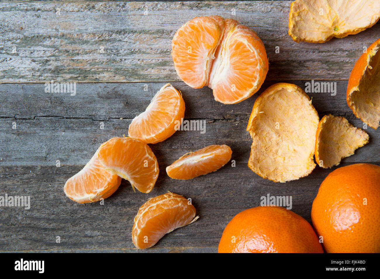 Tangerine sections and peels on old wooden table Stock Photo - Alamy