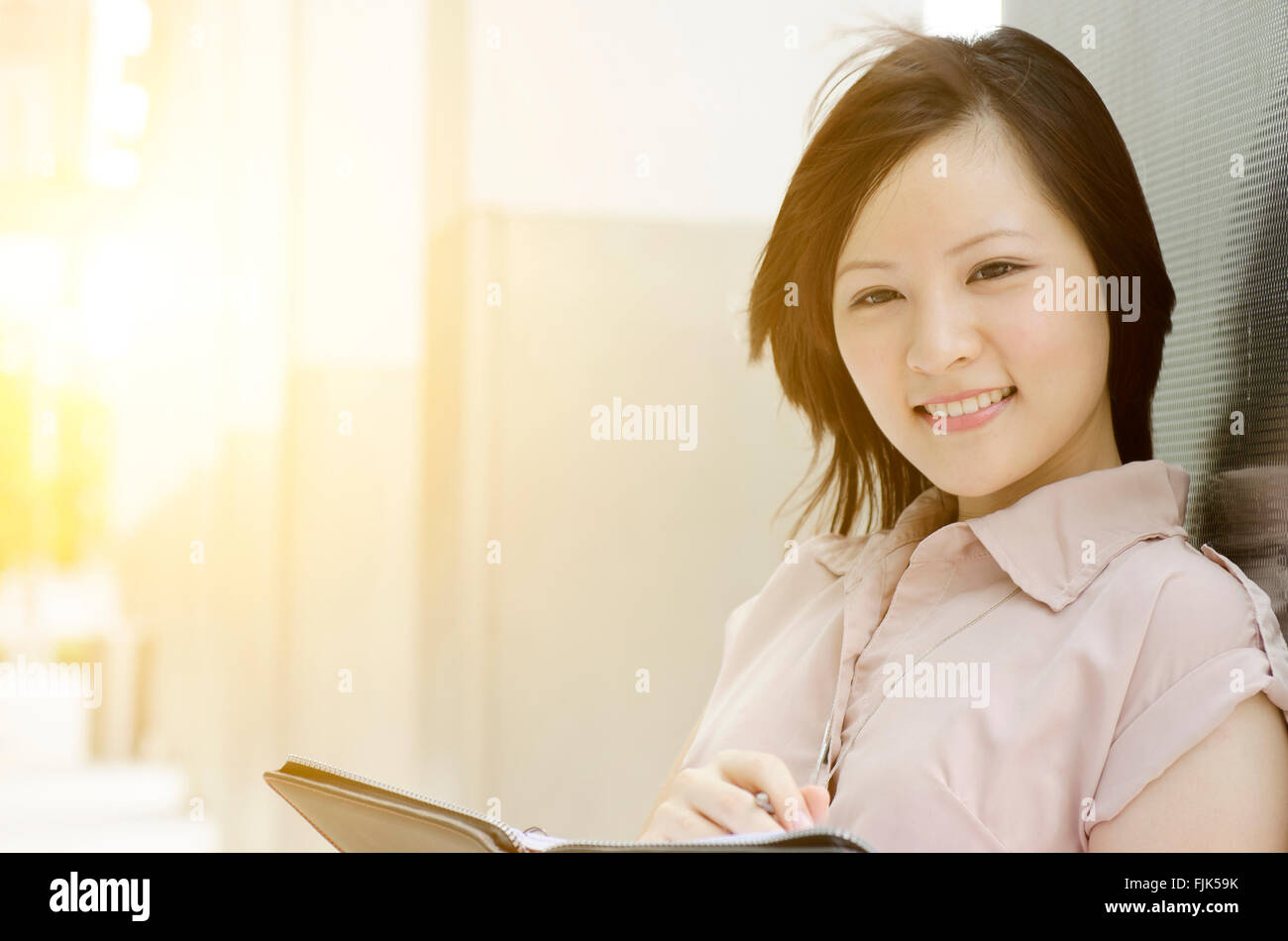 Young Asian woman executive smiling and standing at an office ...