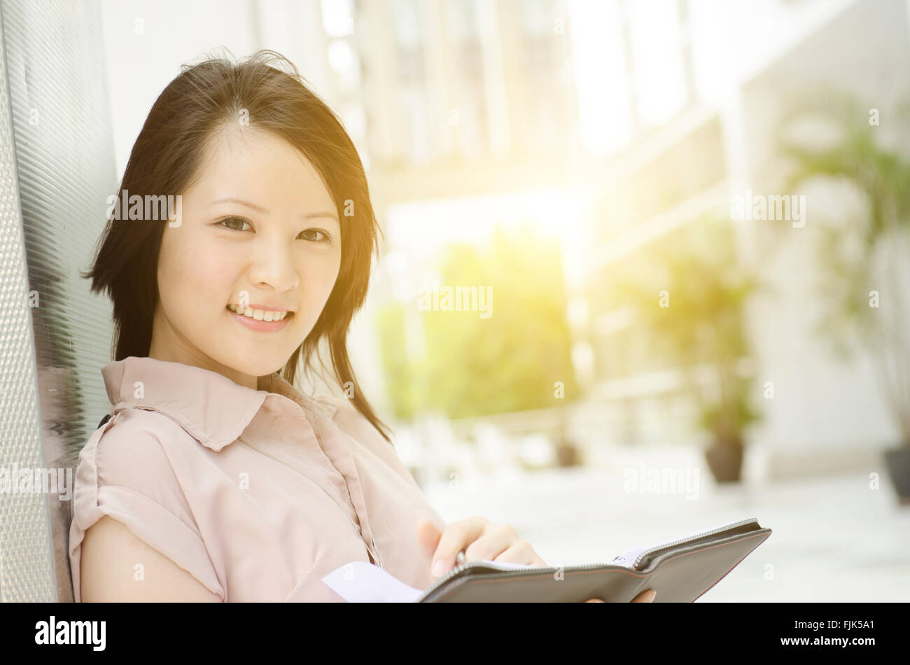 Young Asian woman executive smiling and standing at an office ...