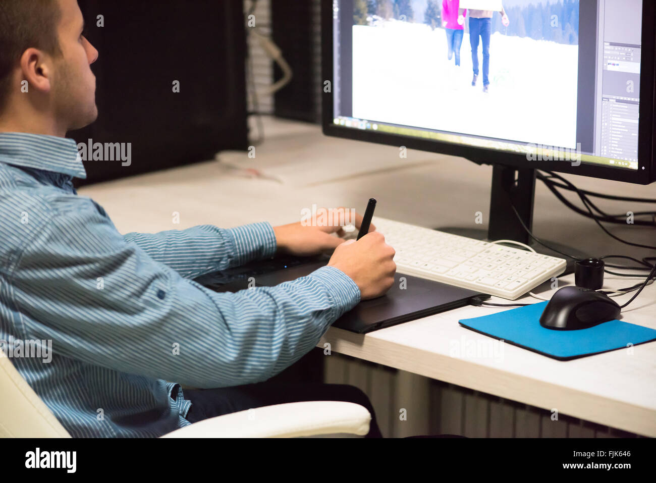 creative worker, photo editor working on graphic tablet at his desktop ...