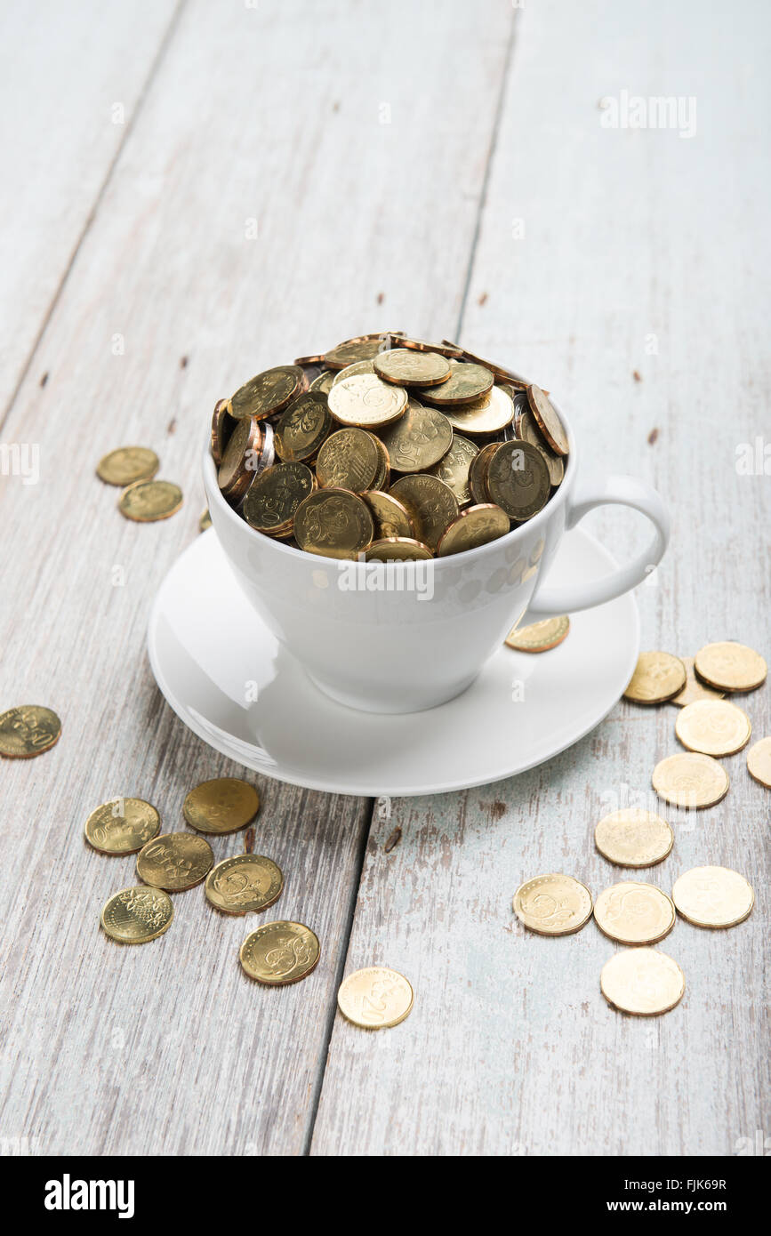 gold coins on coffee cup Stock Photo - Alamy