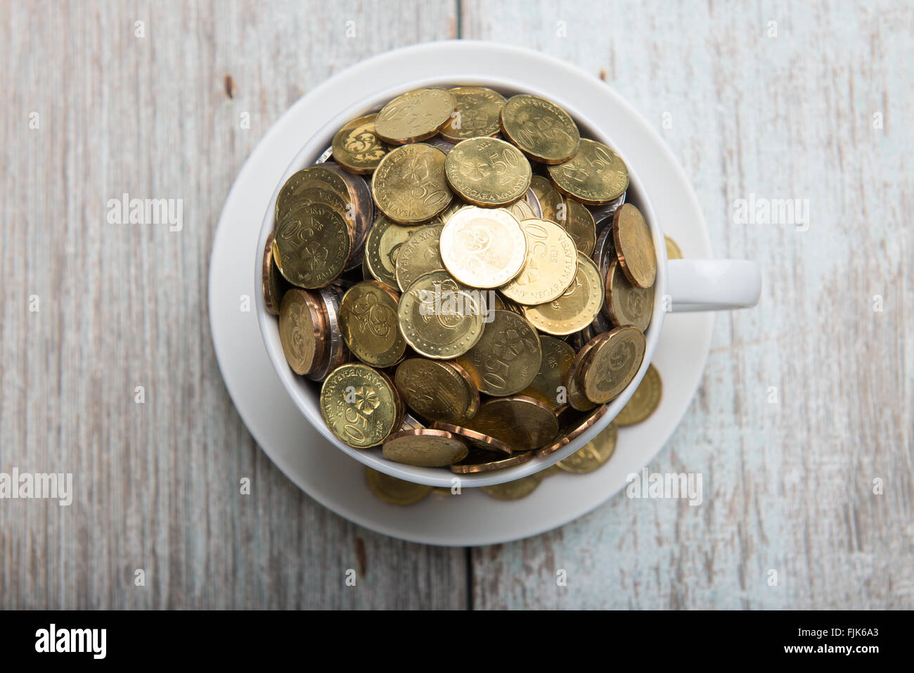 gold coins on a coffee cup top down view Stock Photo - Alamy