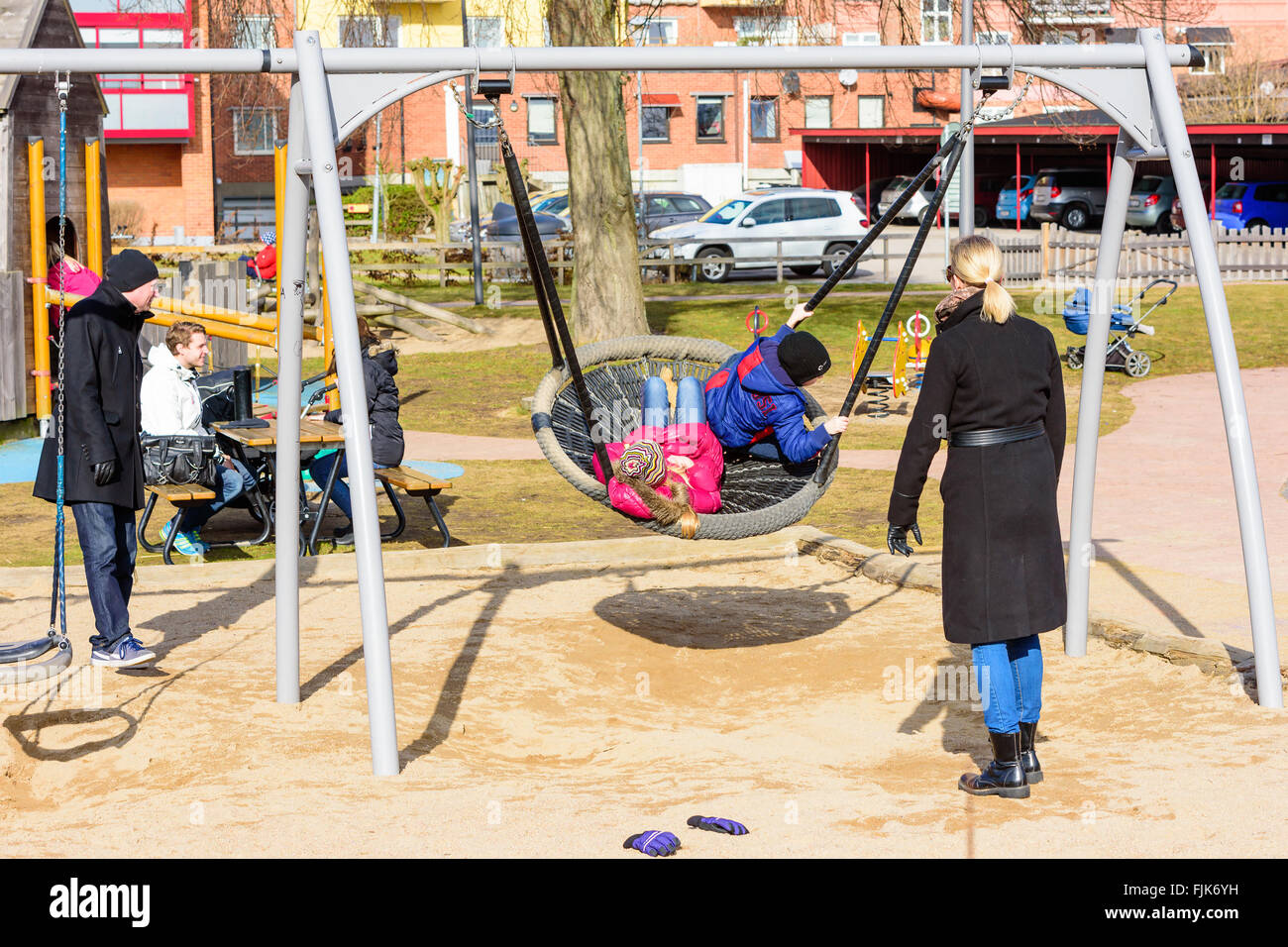 Solvesborg, Sweden - February 27, 2016: Two children in a large swing ...