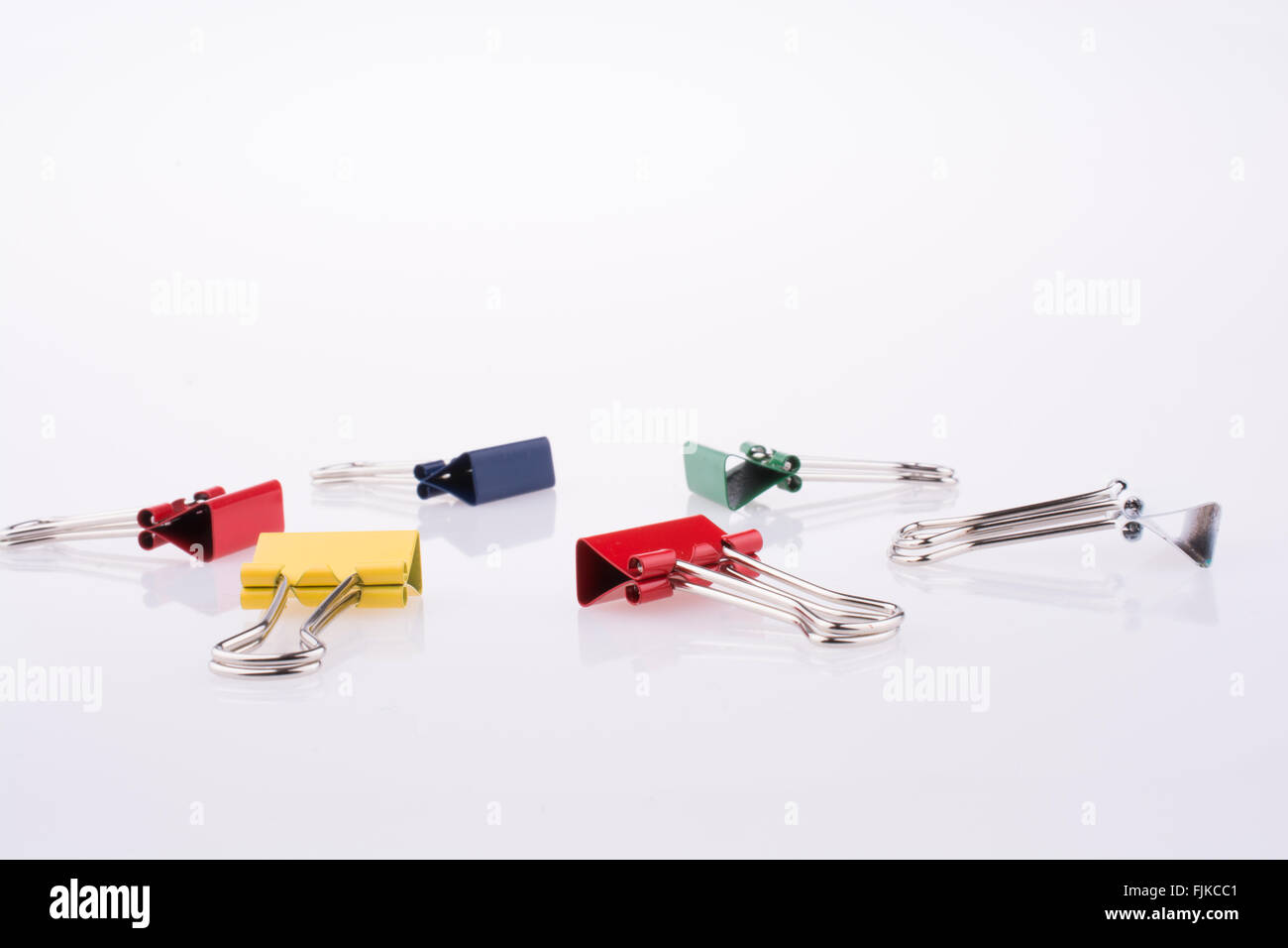 Colored paper clips on a white background Stock Photo - Alamy