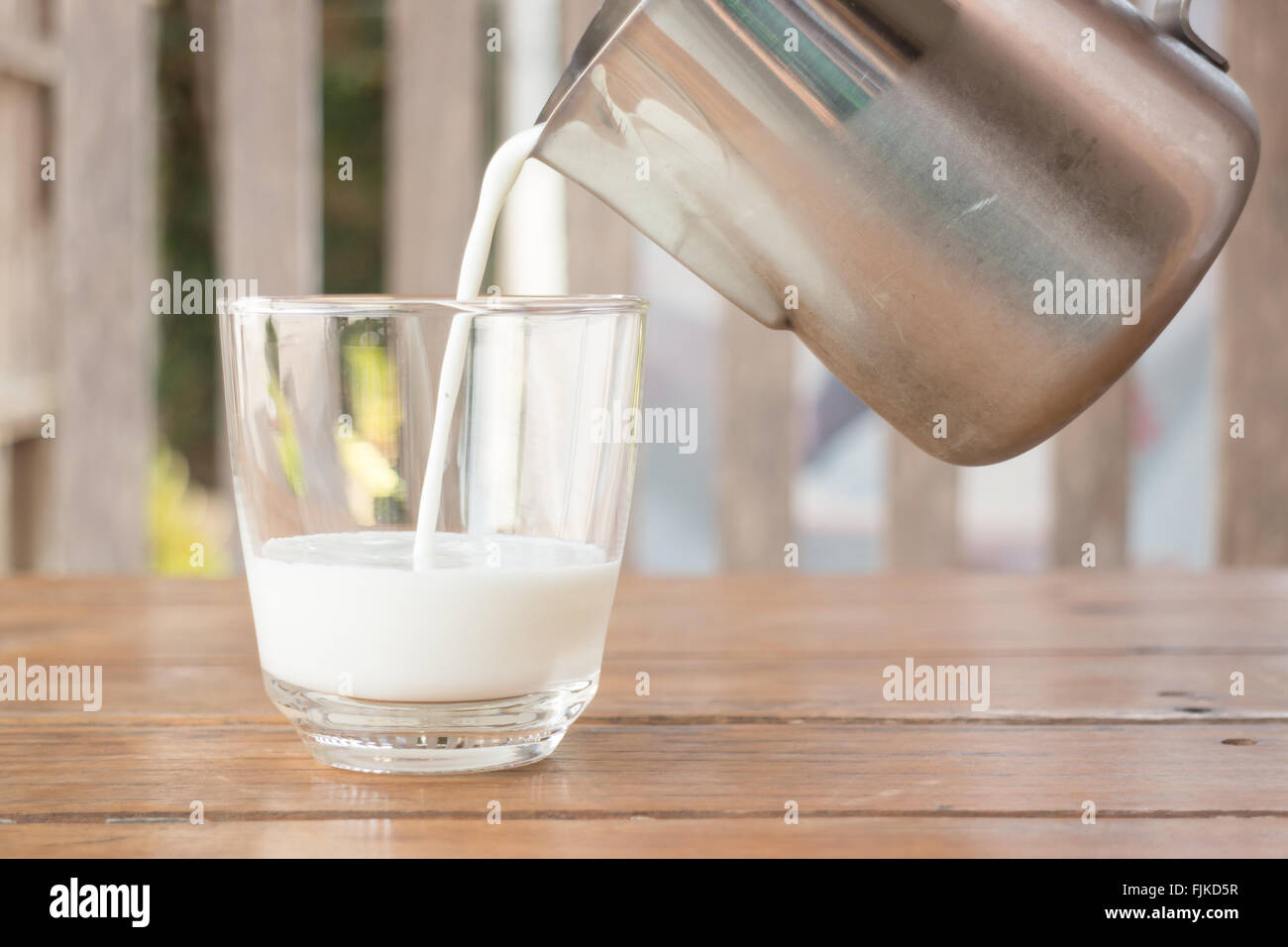 Pour milk from a pitcher into a glass, stock photo Stock Photo - Alamy