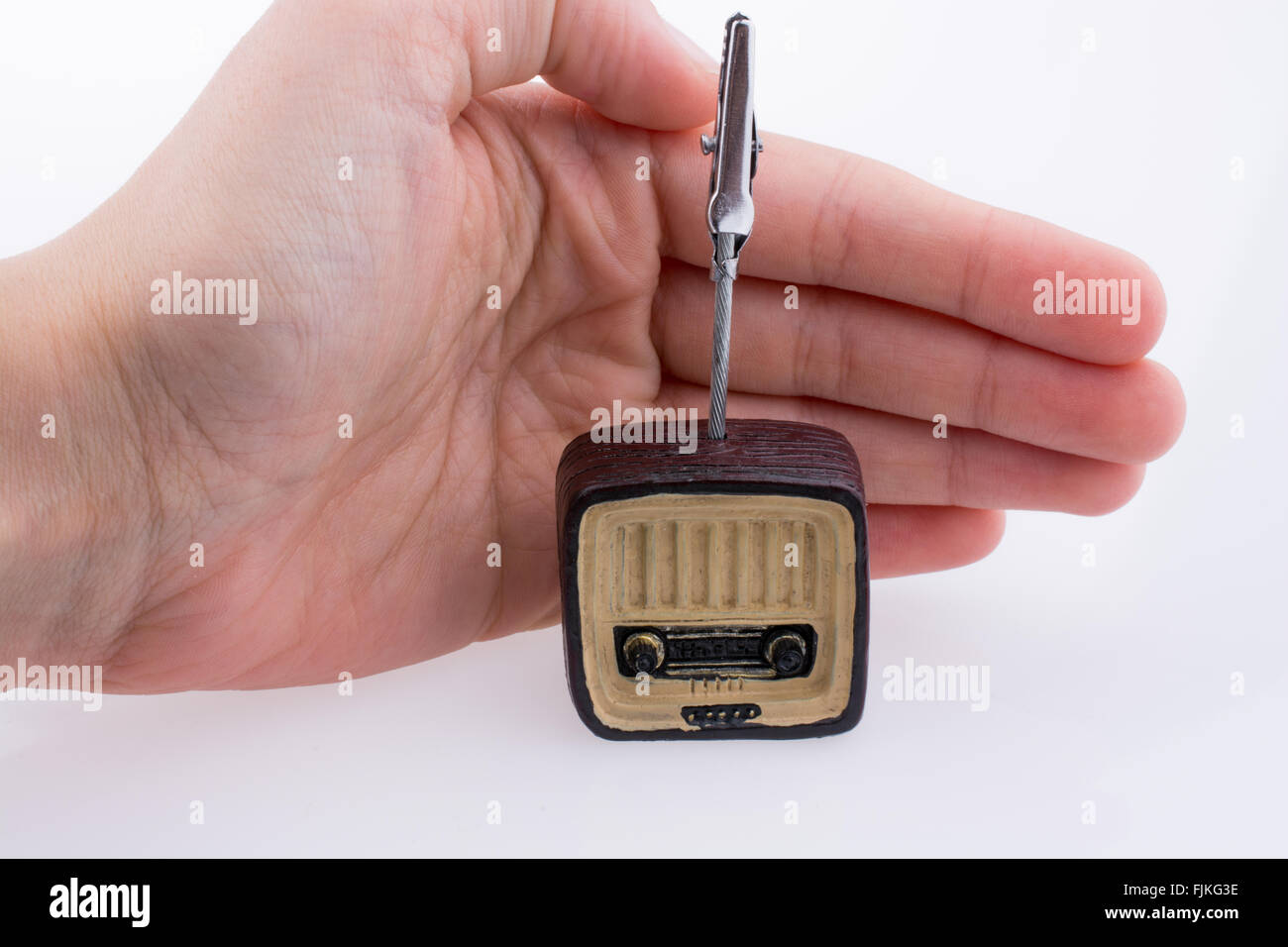 Hand holding a retro TV model on a white background Stock Photo - Alamy
