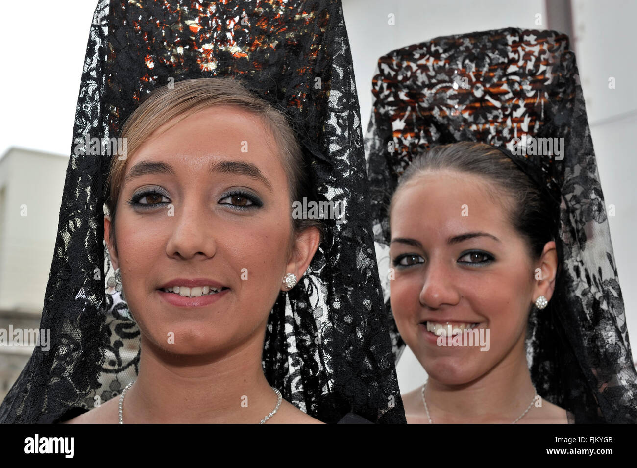 Two women wearing a traditional Spanish "mantilla" that is a religious ...