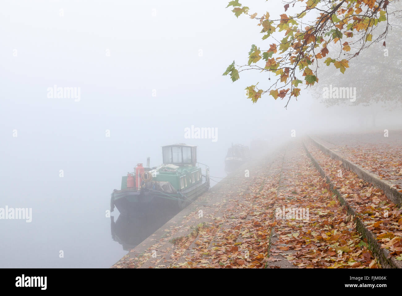 Foggy river scene. Boat moored on the River Trent in Autumn fog, West ...