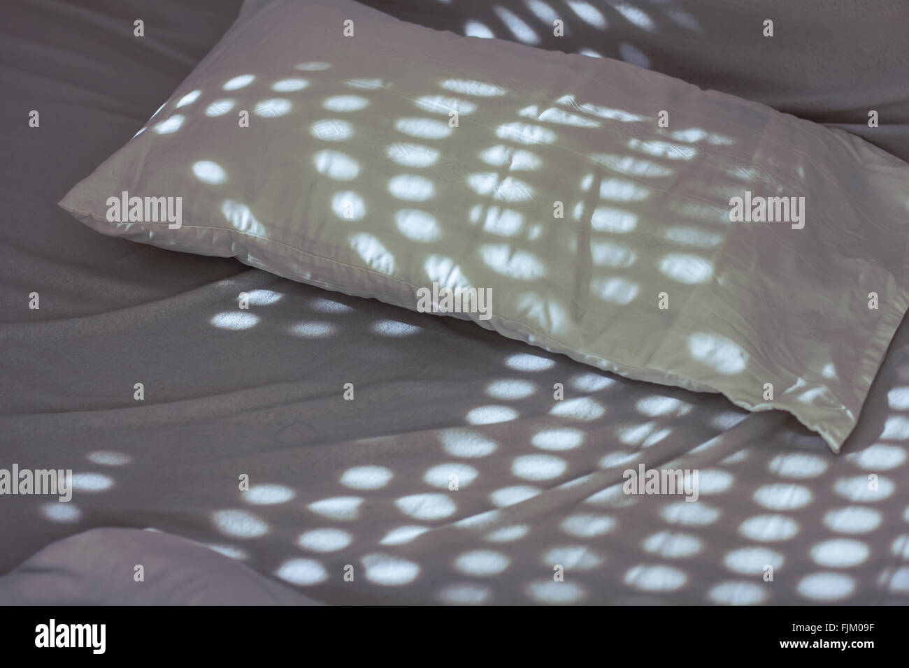 Pillow on the bed with light shadow Stock Photo - Alamy