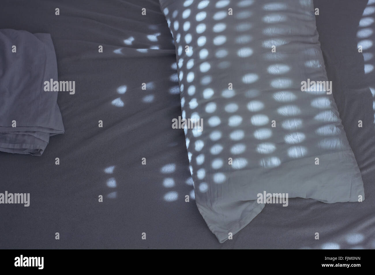 Pillow on the bed with light shadow Stock Photo - Alamy