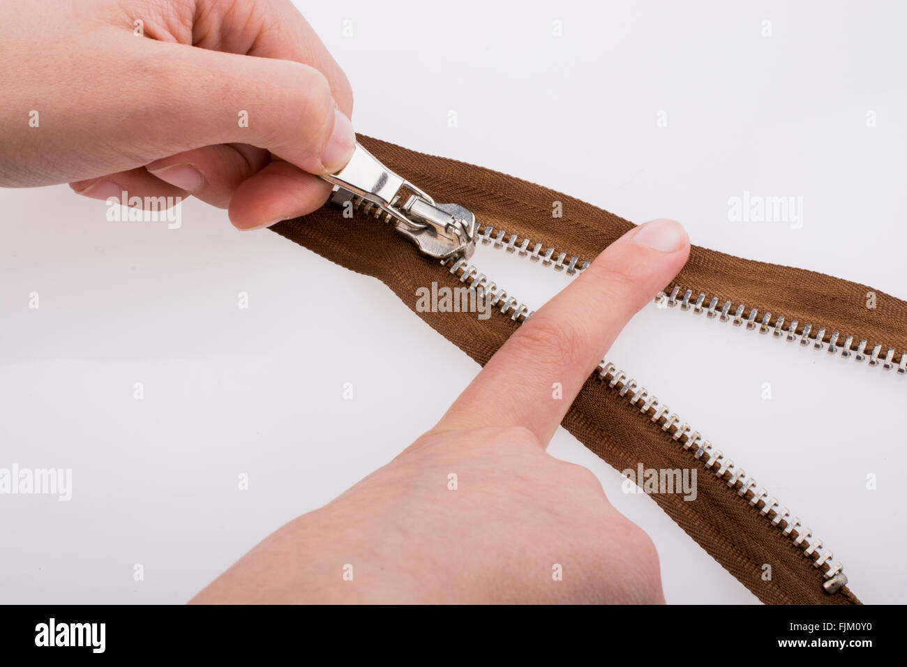 Hand holding color zipper on a white background Stock Photo - Alamy