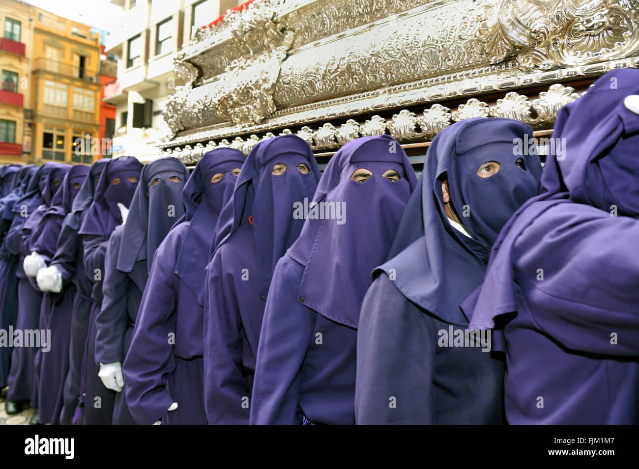 Processions of Nazarenos walk the streets at night during Semana Santa ...