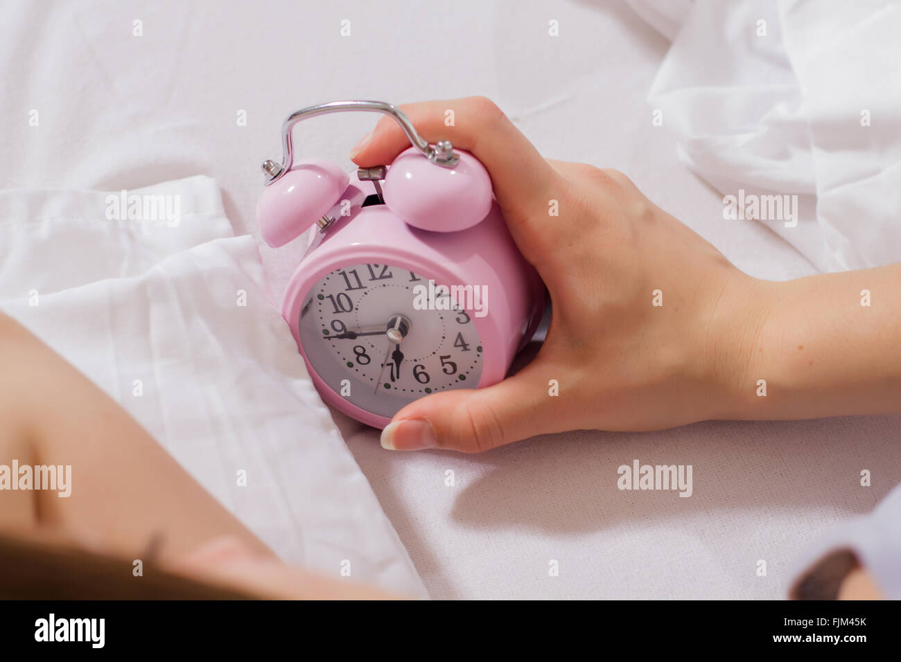 Female hand stopping alarm clock Stock Photo - Alamy