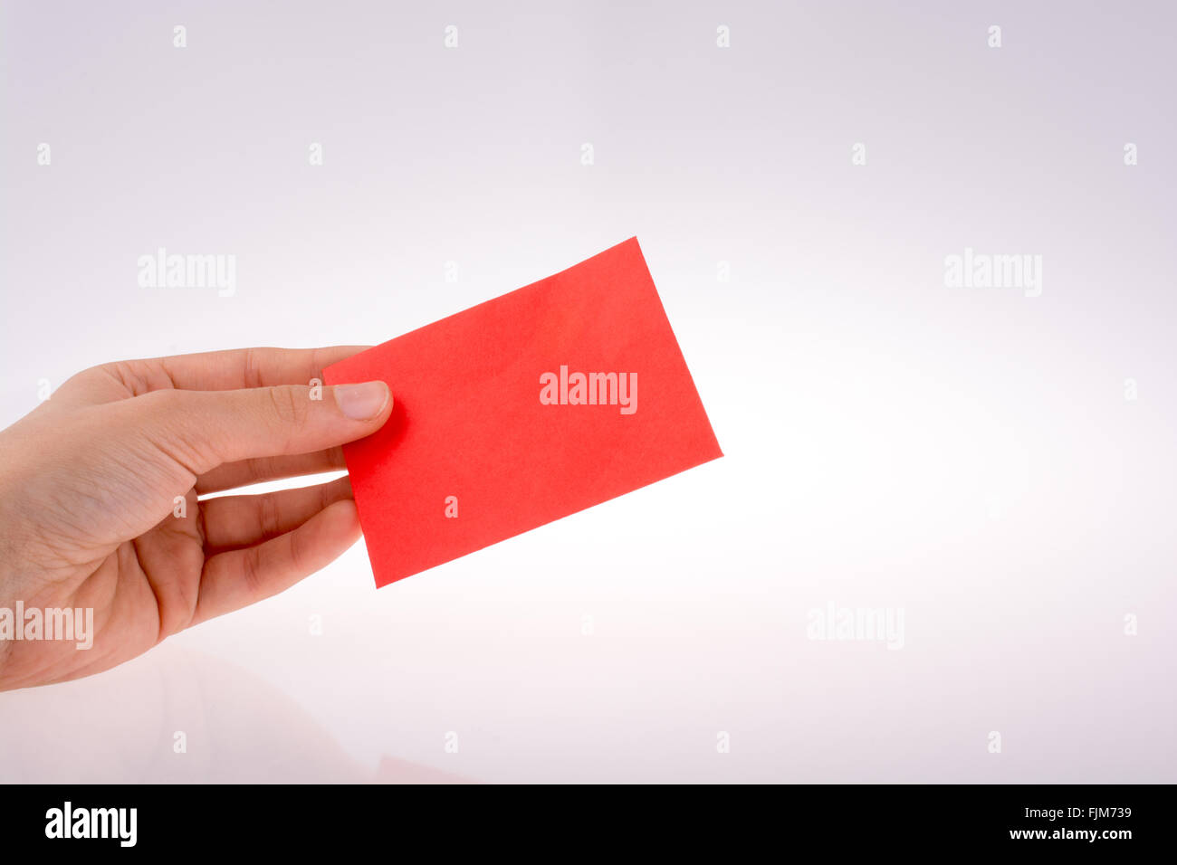 hand holding a red note paper on white background Stock Photo - Alamy