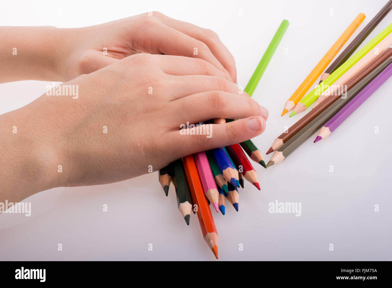 Hand holding color pencils on a white background Stock Photo - Alamy