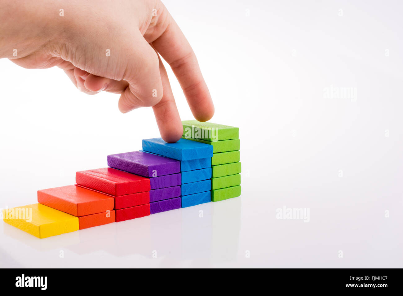 Hand playing with colored domino on white background Stock Photo - Alamy
