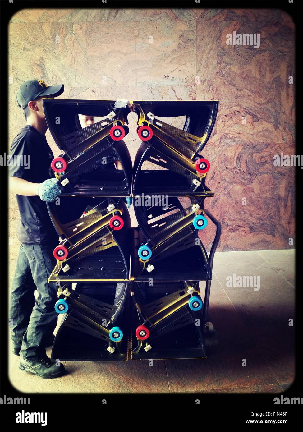 Delivery man pushing hand truck indoors hi-res stock photography and ...