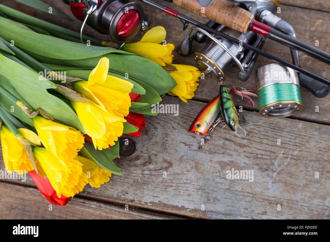 fishing tackles with bouquet of spring flowers narcissus and tulips on ...
