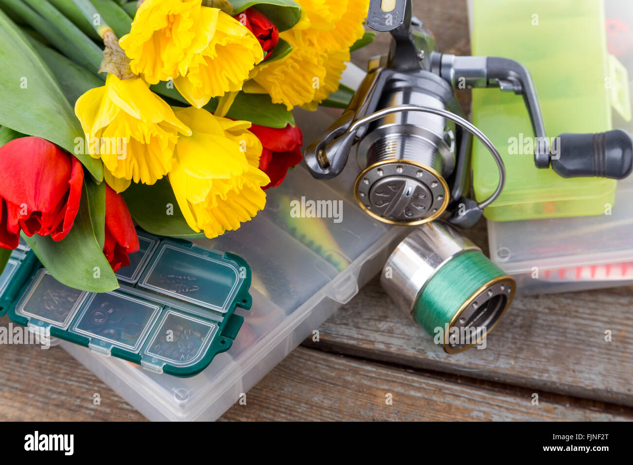 fishing tackles with bouquet of spring flowers narcissus and tulips on ...