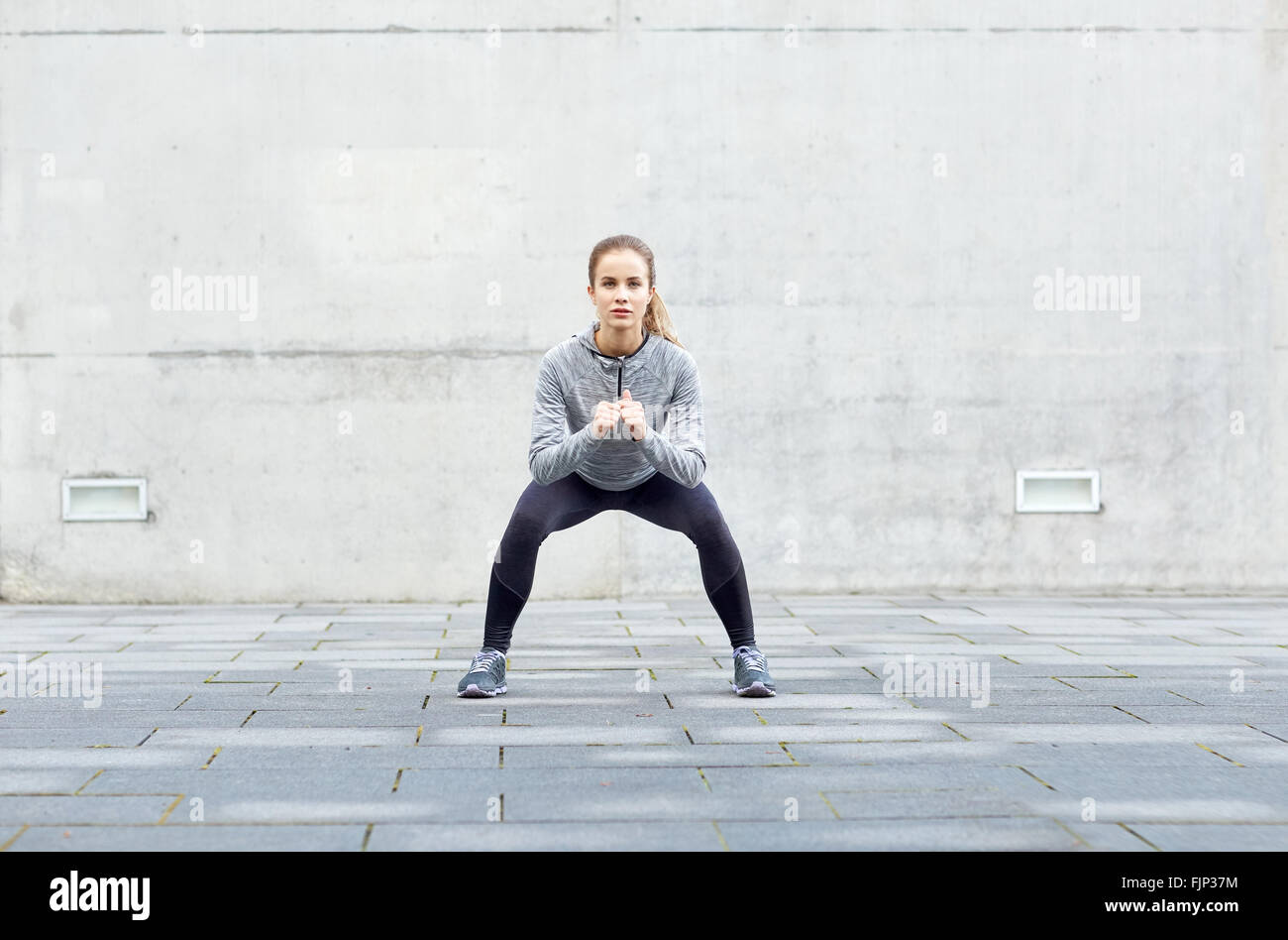 woman doing squats and exercising outdoors Stock Photo - Alamy