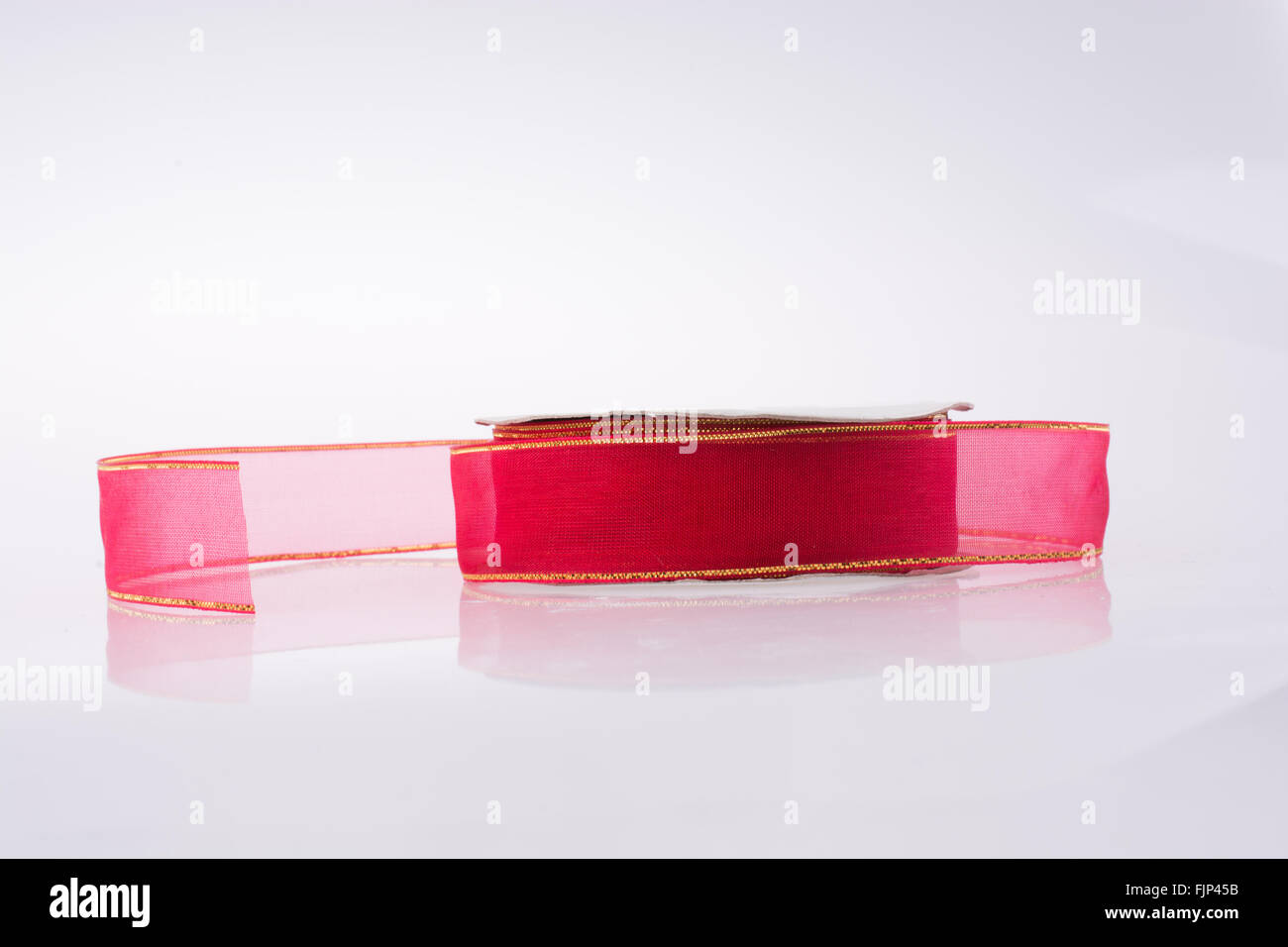 A roll of red ribbon, isolated on white Stock Photo - Alamy