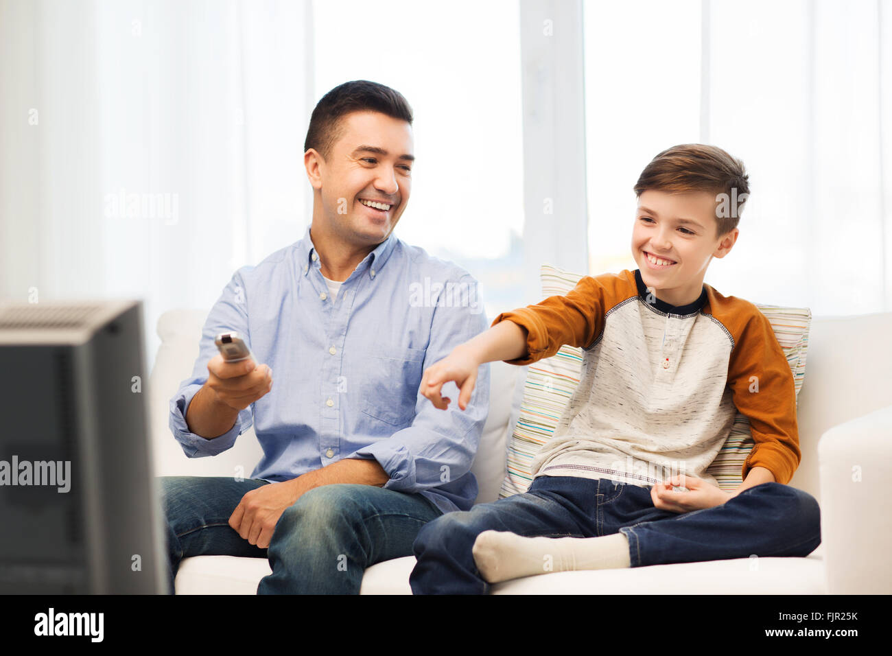 smiling father and son watching tv at home Stock Photo - Alamy