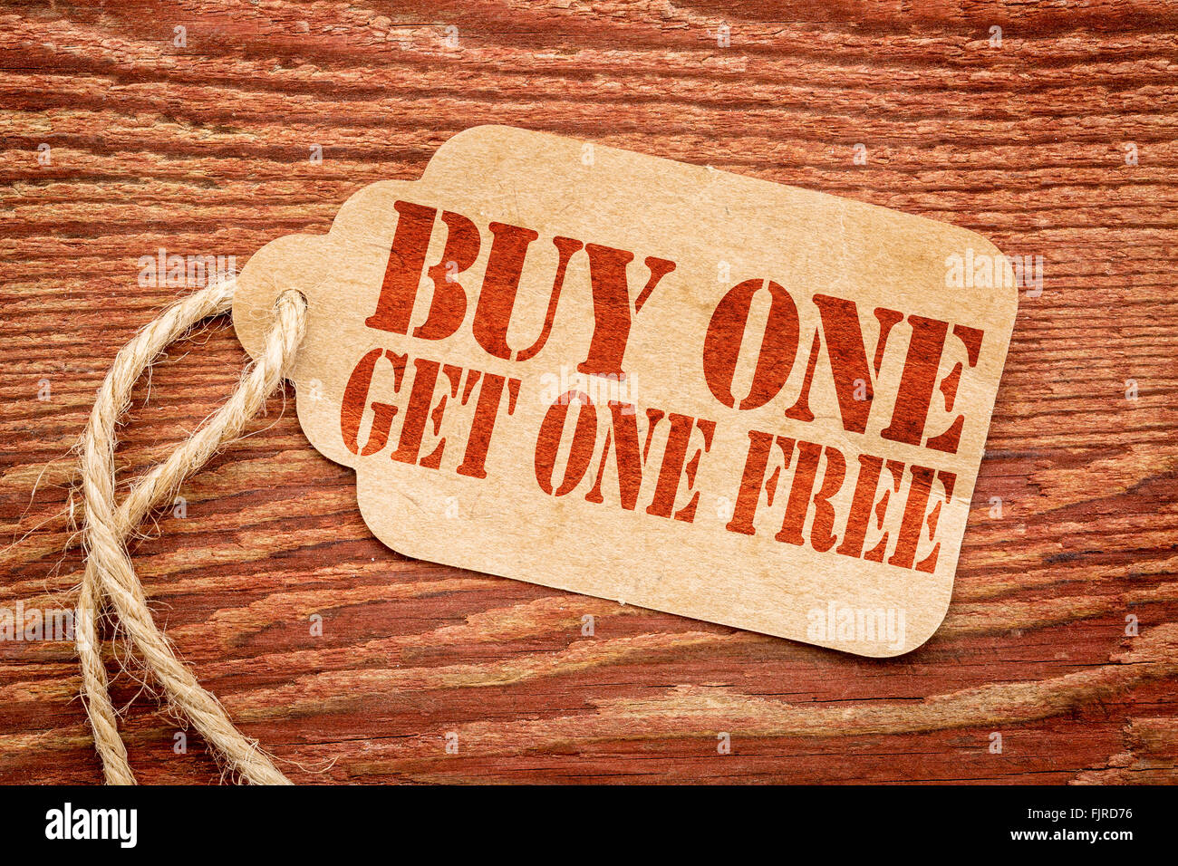 buy one get one free sale sign - a paper price tag against rustic red ...