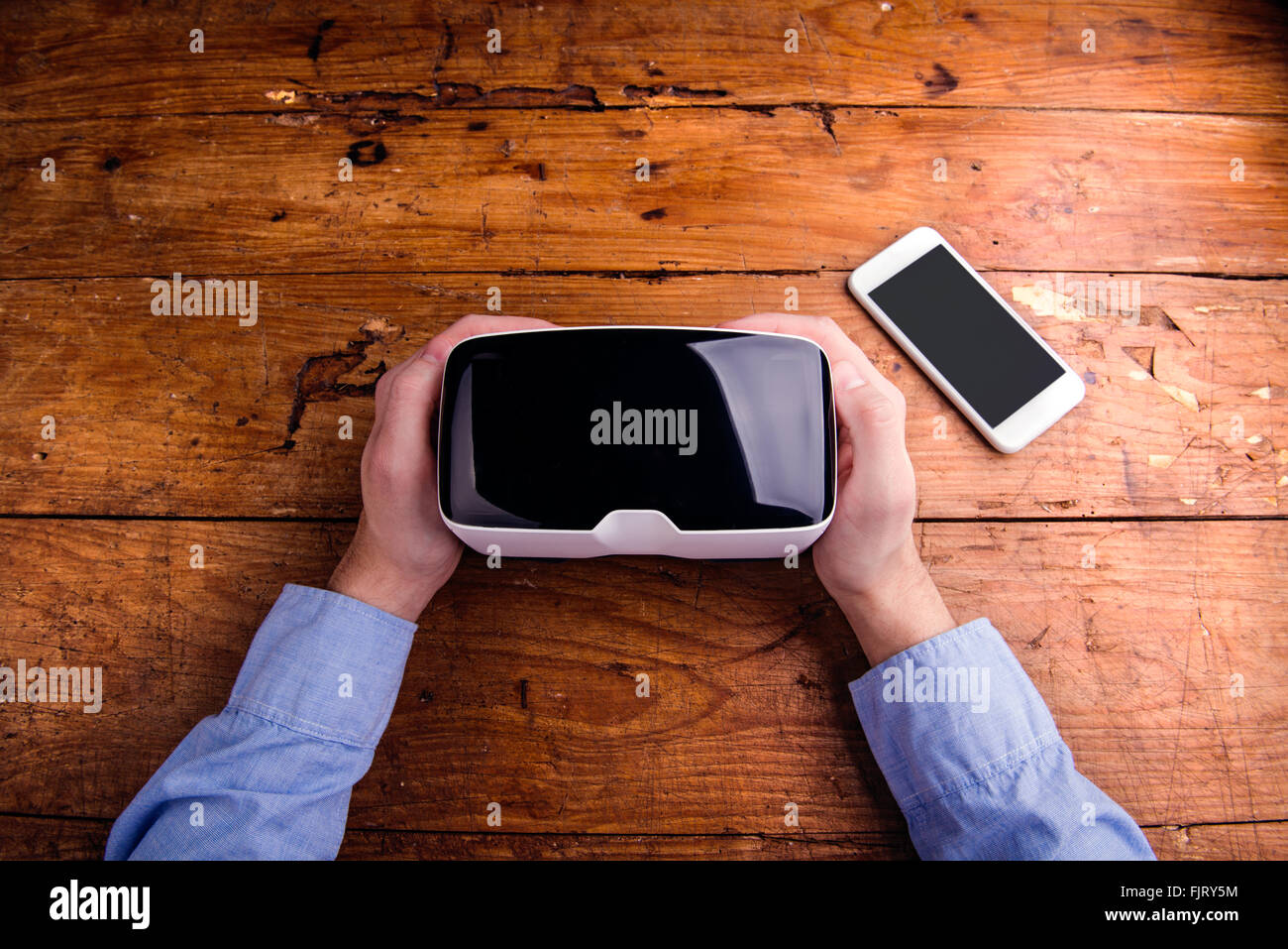 Hands of man holding virtual reality goggles and smartphone Stock Photo ...