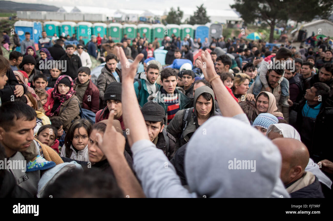 Refugees standing in front of the border fence in a refugee camp in ...