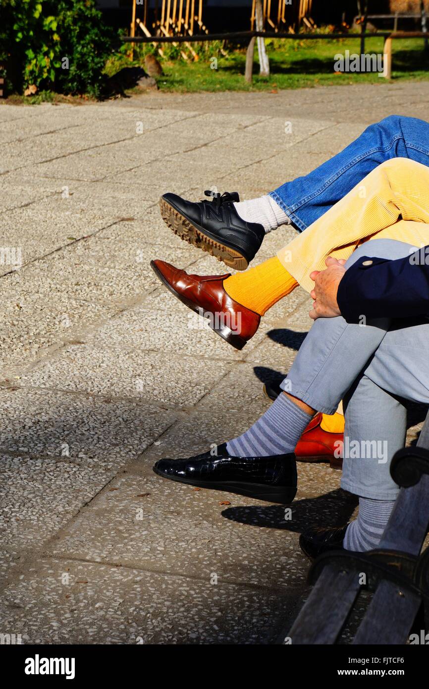 Low Section Of Men Sitting On Bench At Park Stock Photo - Alamy