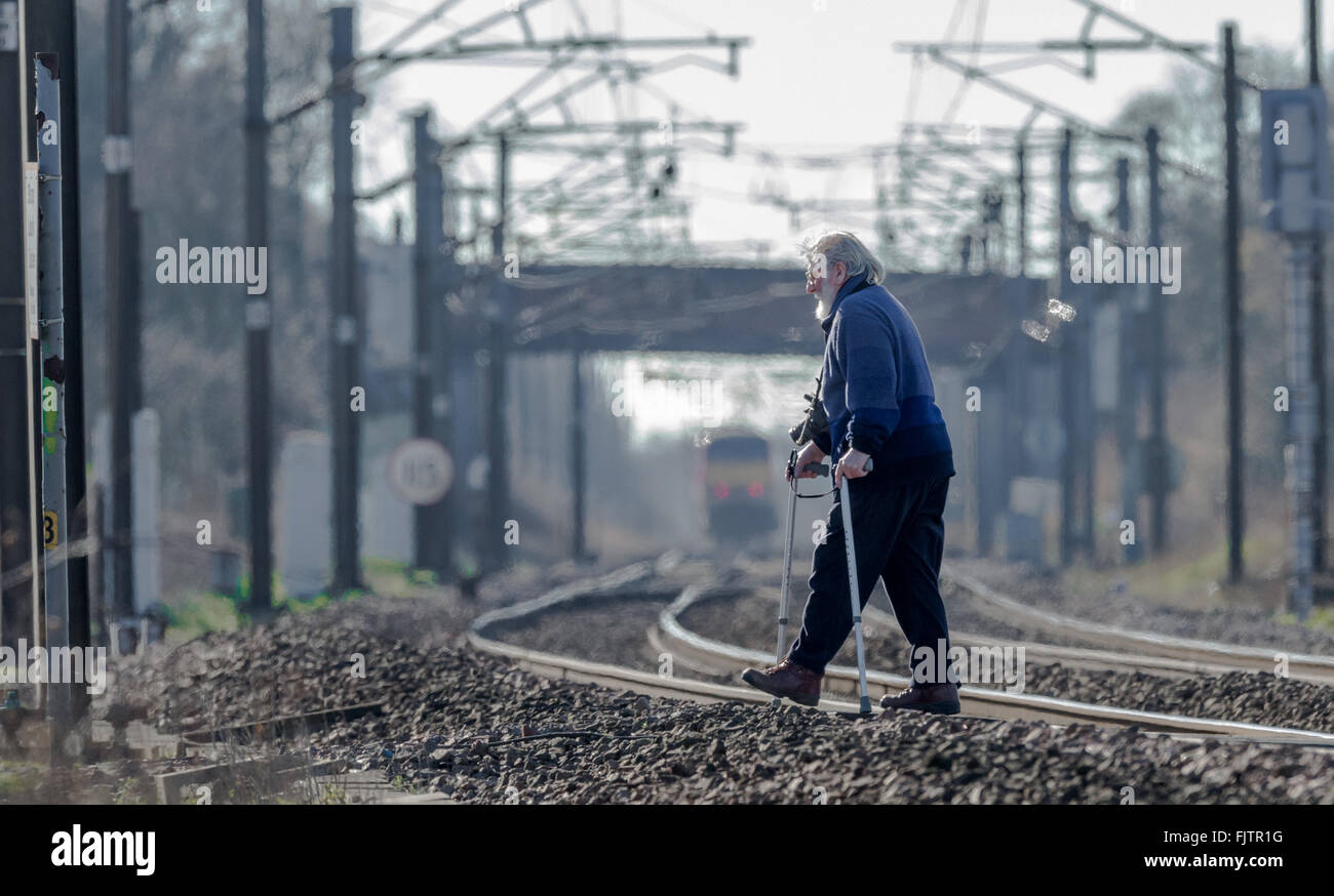 Male using the pedestrian level crossing on the East coast main line ...