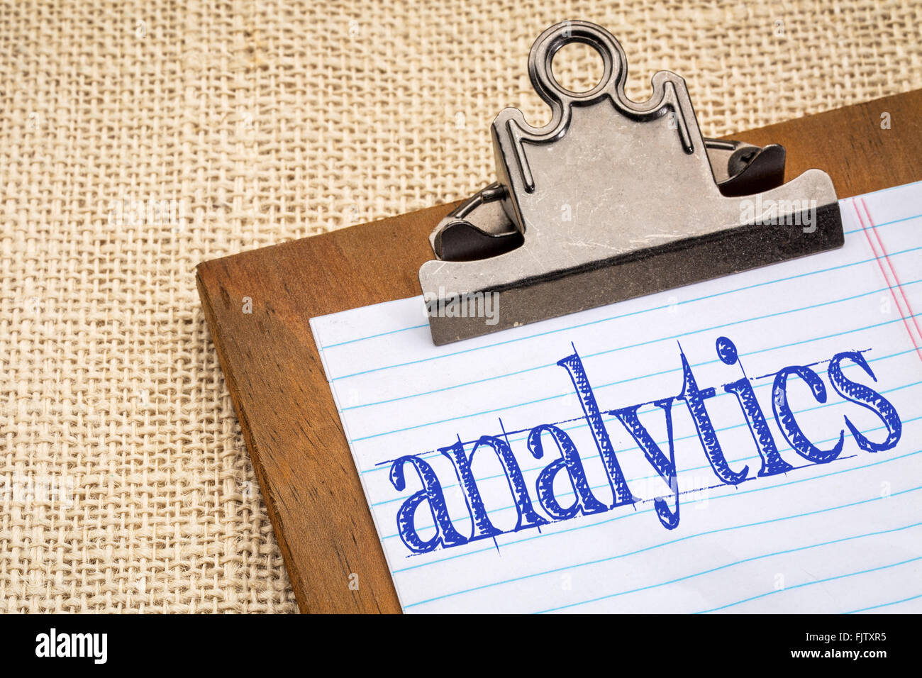 analytics words on clipboard against burlap canvas Stock Photo - Alamy