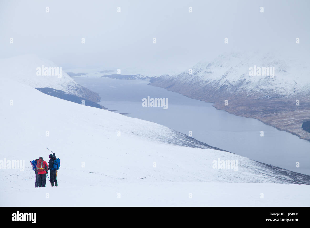 Three walkers checking their map in winter conditions on the Scottish ...