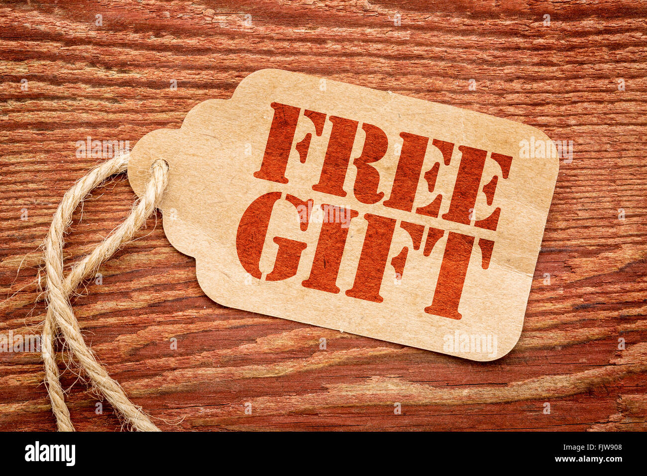 free gift sign - red stencil text a paper price tag against rustic wood ...