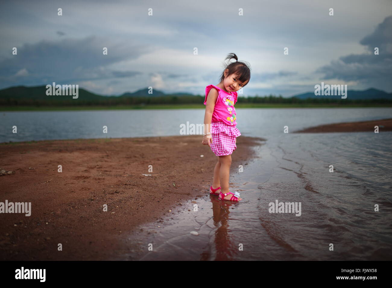 Cute little asian girl playing at the beautiful lake Stock Photo - Alamy