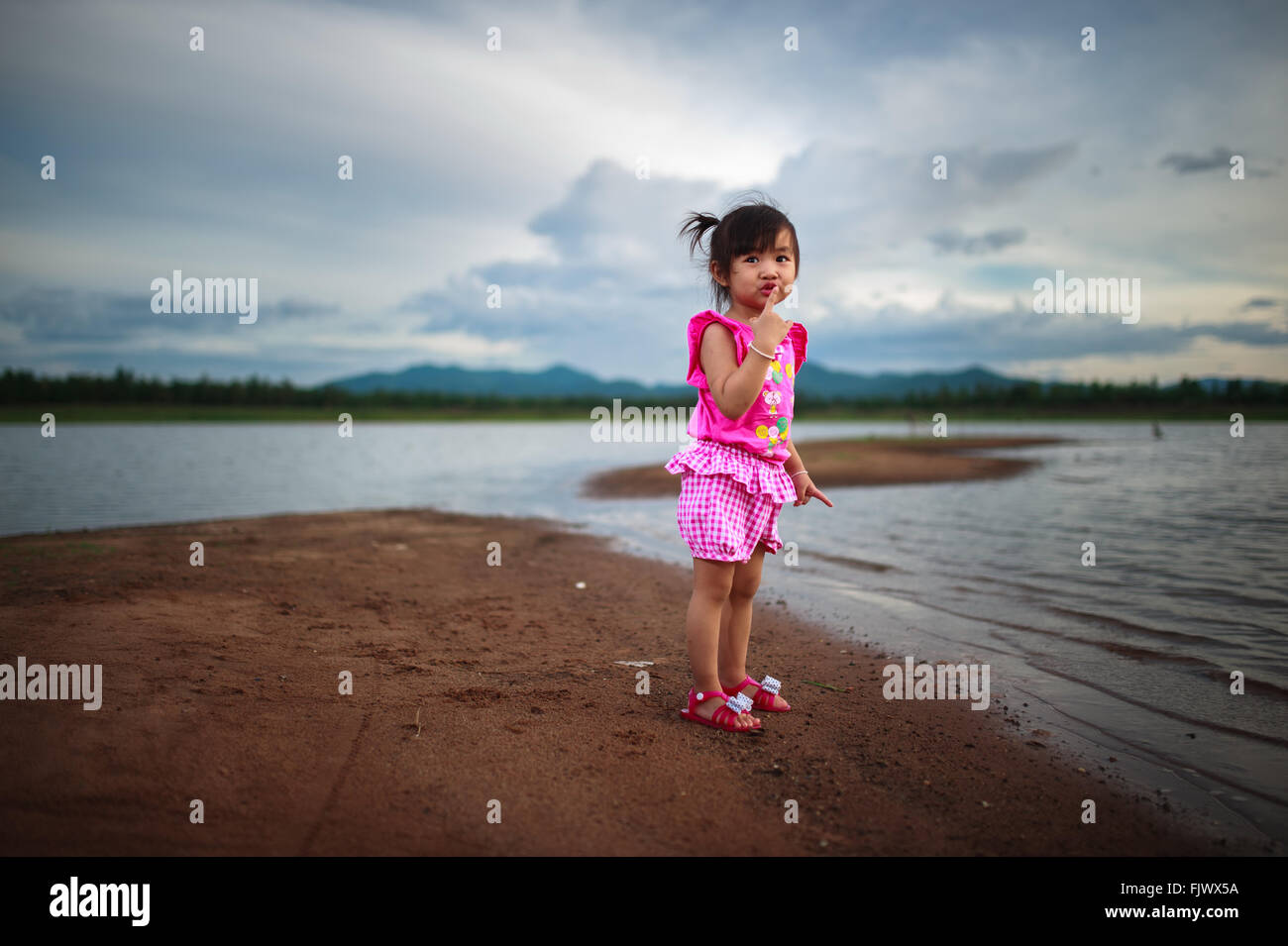 Cute little asian girl playing at the beautiful lake Stock Photo - Alamy