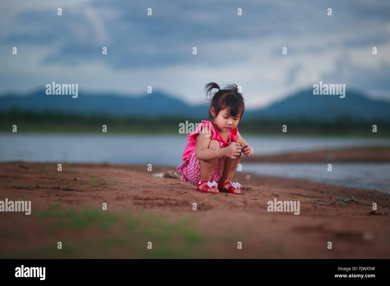 Cute little asian girl playing at the beautiful lake Stock Photo - Alamy