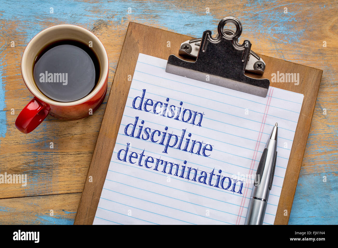 Decision, discipline, and determination words on a clipboard with a cup ...
