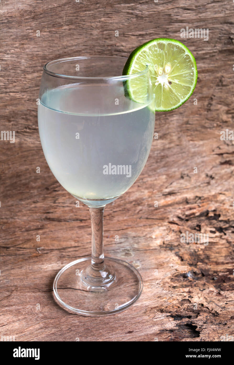 green lemonade garnish with sliced green lime on teak wooden background ...