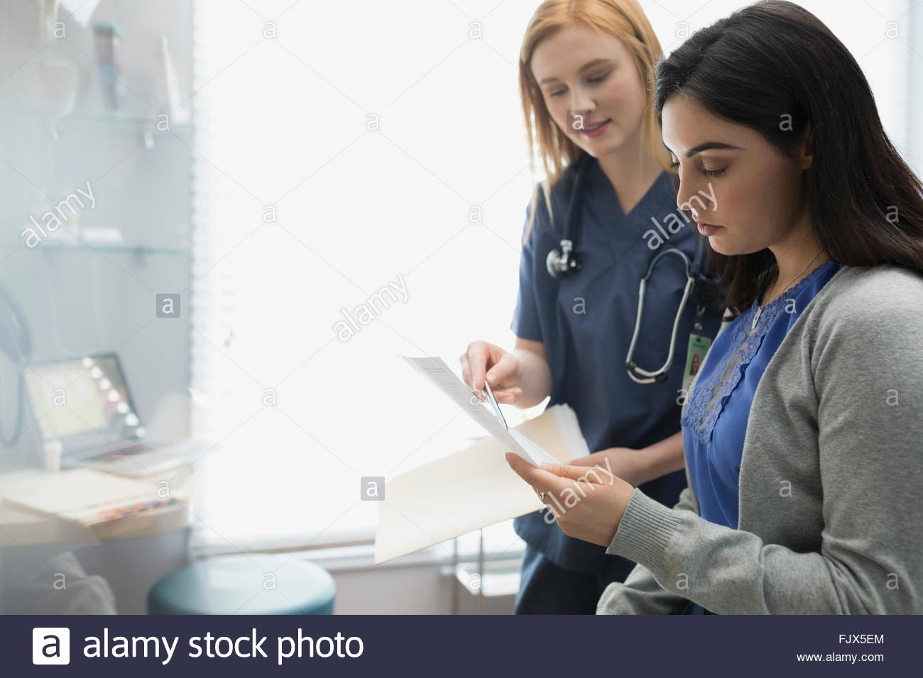 Nurse discussing medical record with patient examination room Stock ...