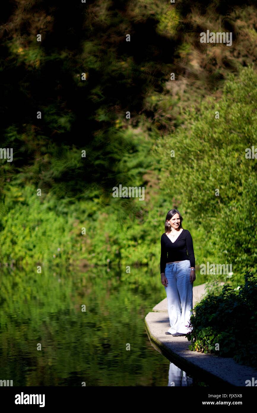 Lady in woods surrounded by nature, lake, water reflection Stock Photo ...