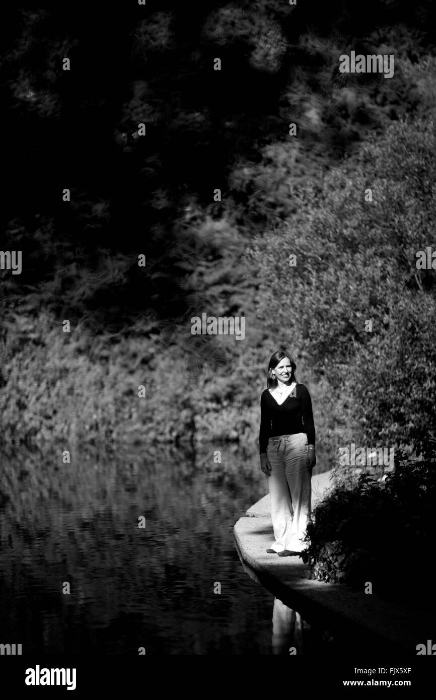 Lady in woods surrounded by nature, lake, water reflection Stock Photo ...