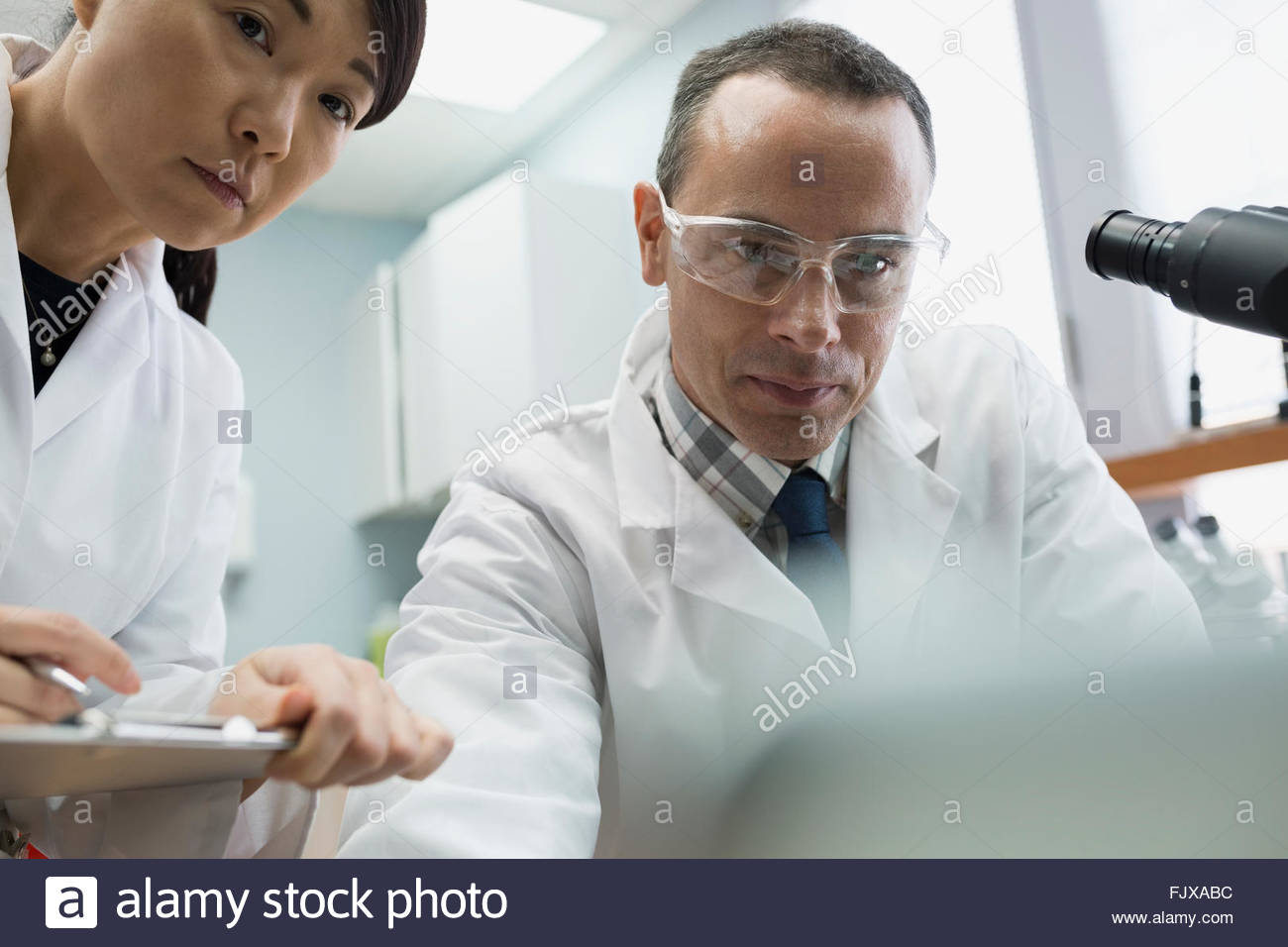 Medical scientists working at microscope in laboratory Stock Photo - Alamy