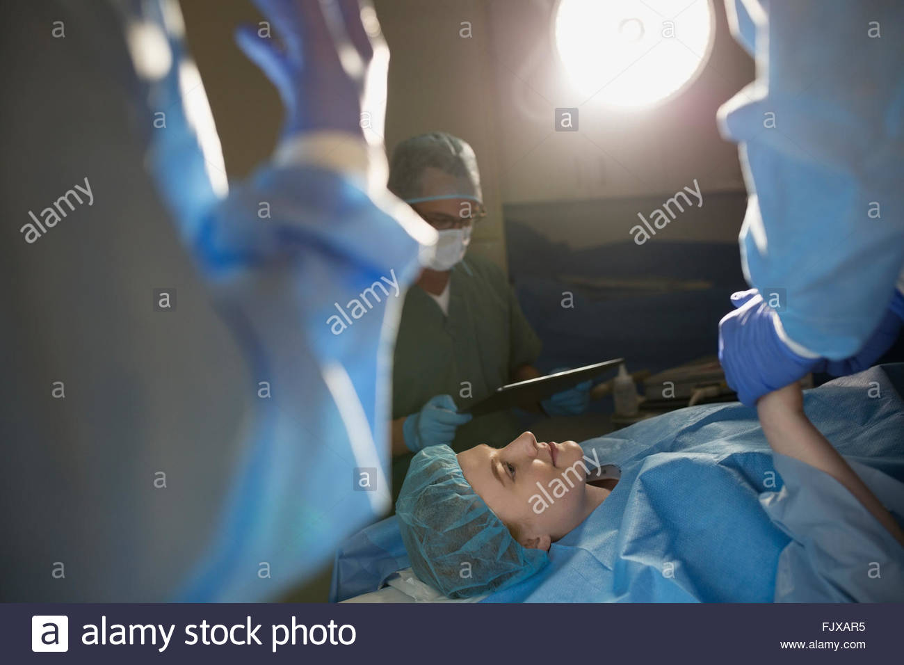 Plastic surgeons preparing patient for surgery operating room Stock ...